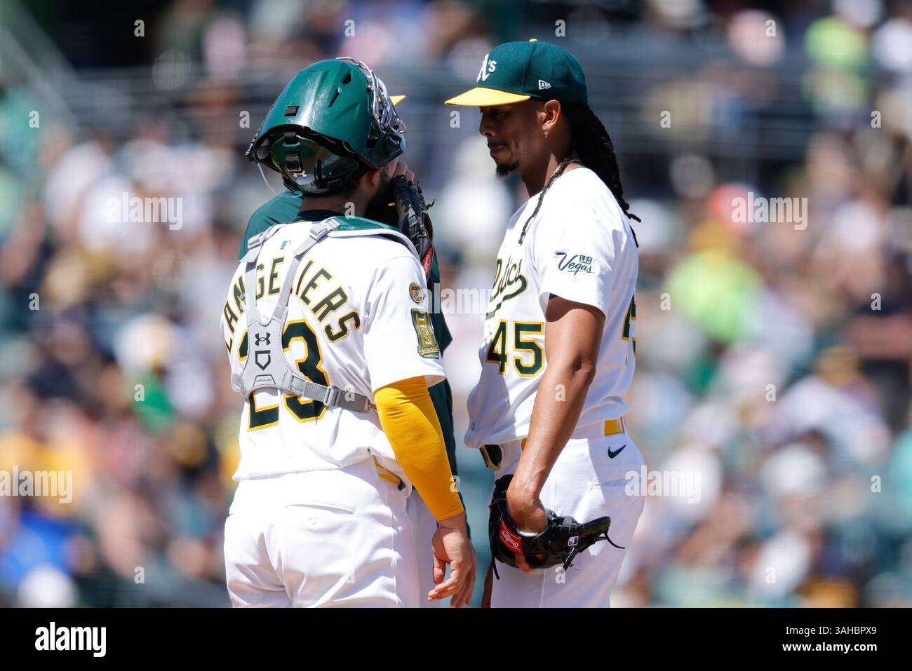 Athletics catcher Shea Langeliers, left, meets with pitcher Osvaldo ...