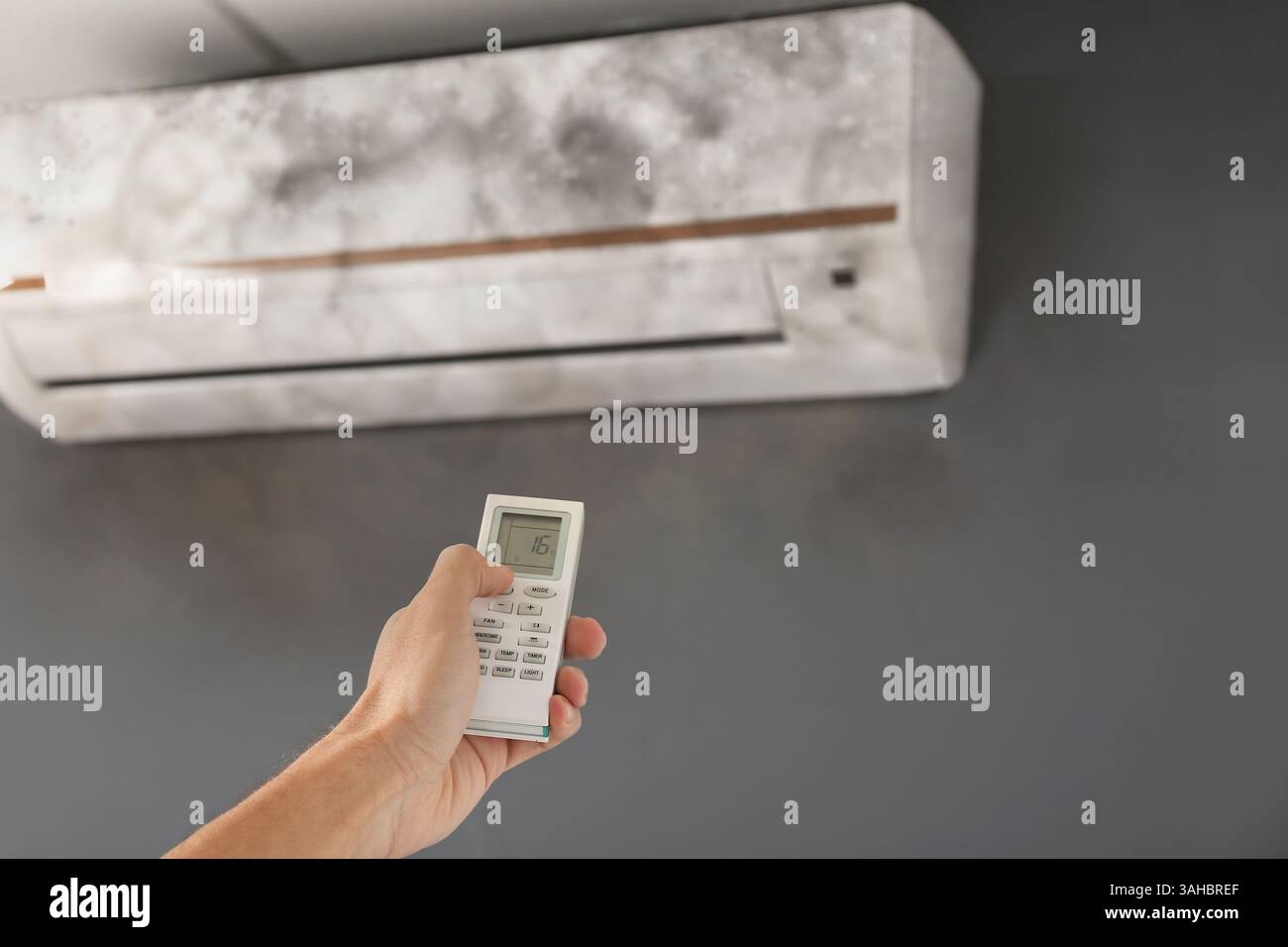Man using air conditioner covered with mildew Stock Photo - Alamy