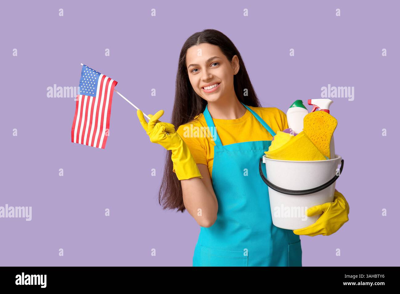 Female janitor holding bucket with cleaning supplies and USA flag on ...
