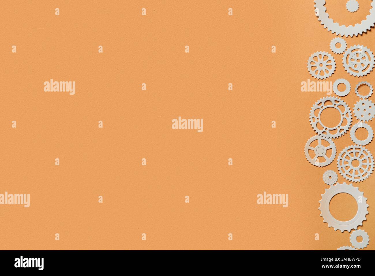 Grey paper gears on orange background Stock Photo - Alamy