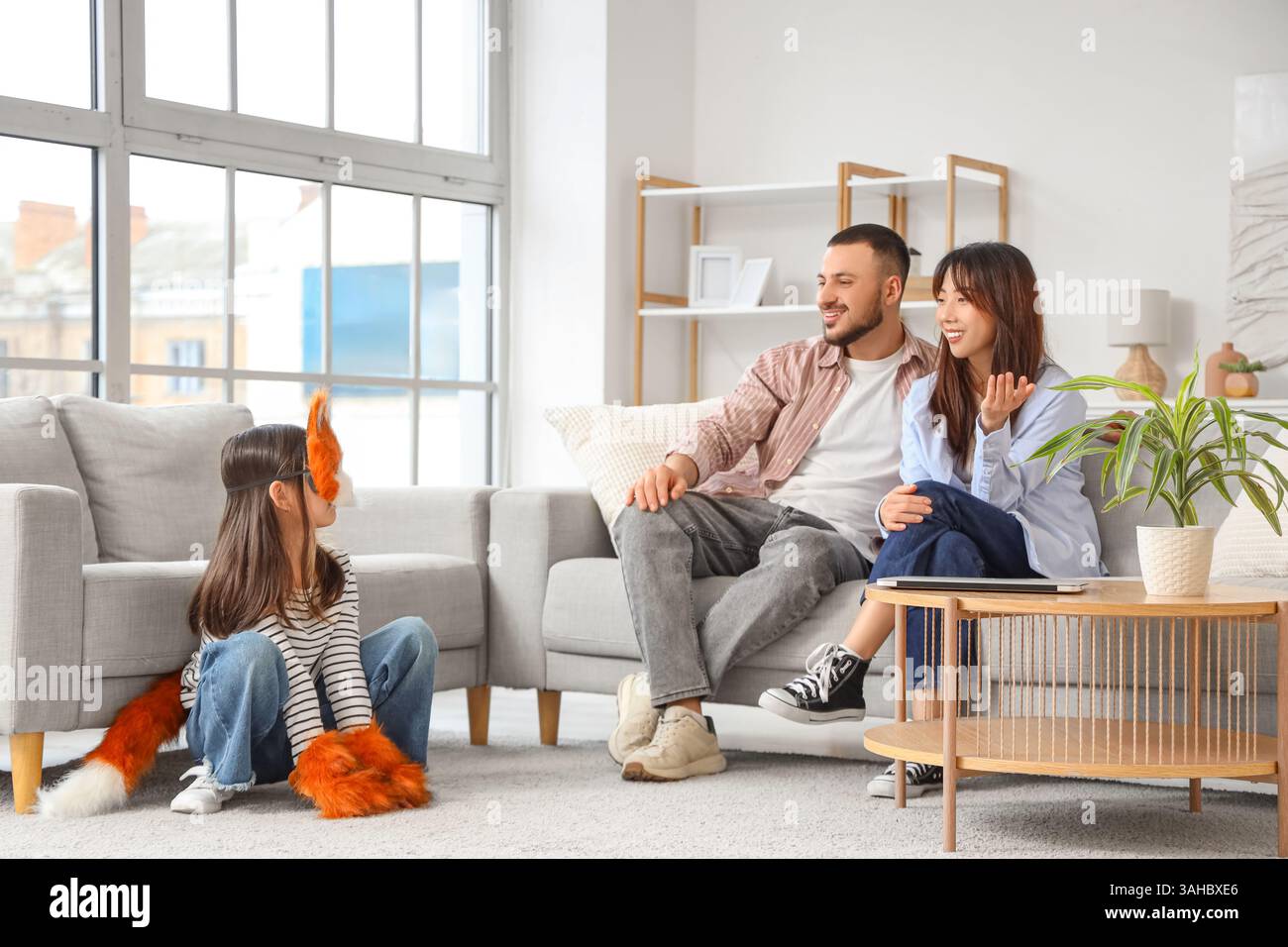 Quadrober girl in fox mask and her parents at home Stock Photo - Alamy