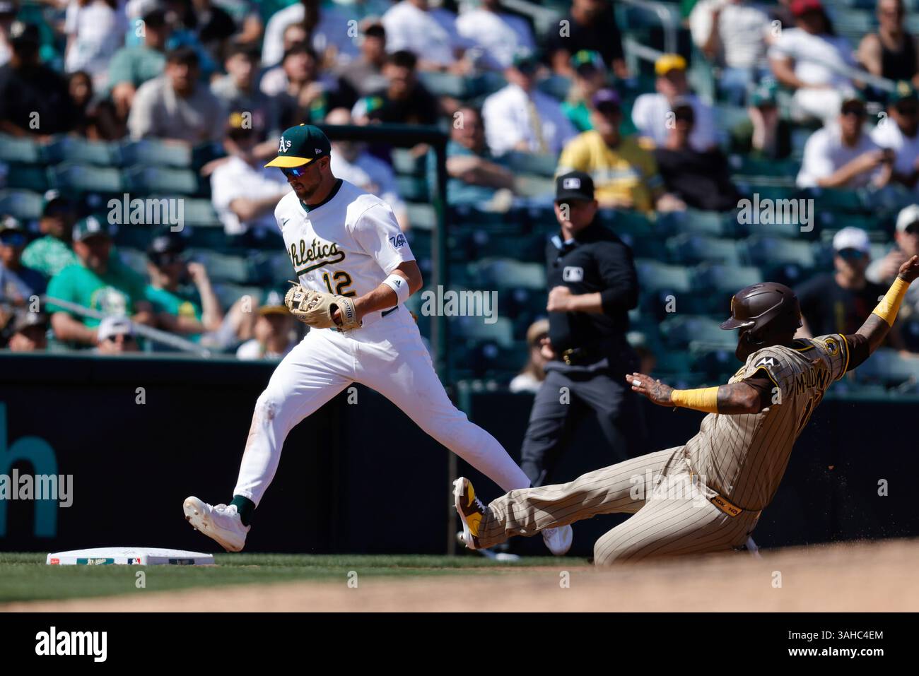 Athletics shortstop Max Schuemann (12) steps on thrid base to force out ...