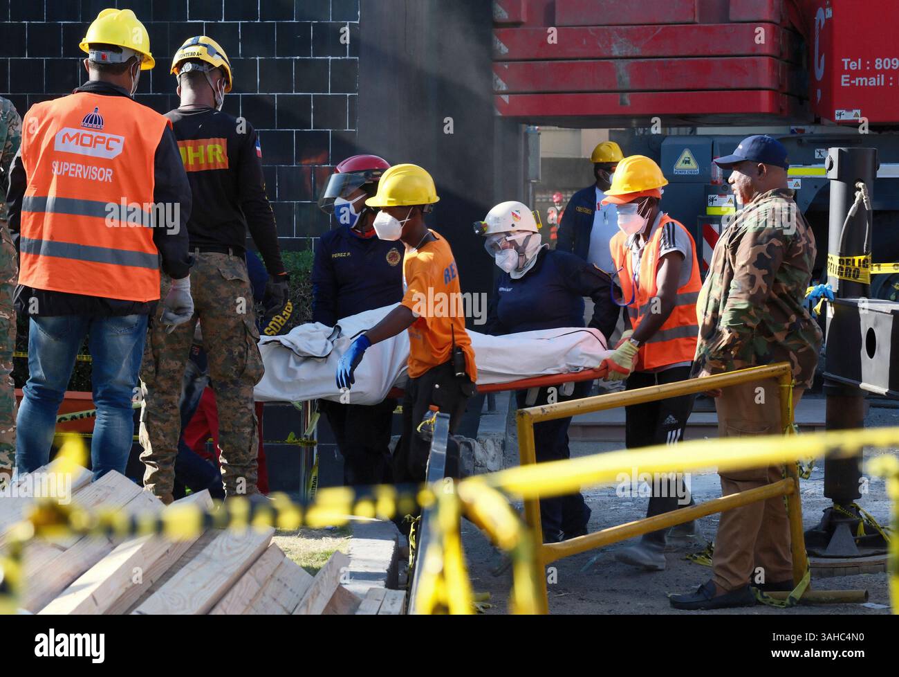 Rescue workers recover the body of a victim who died when the roof ...