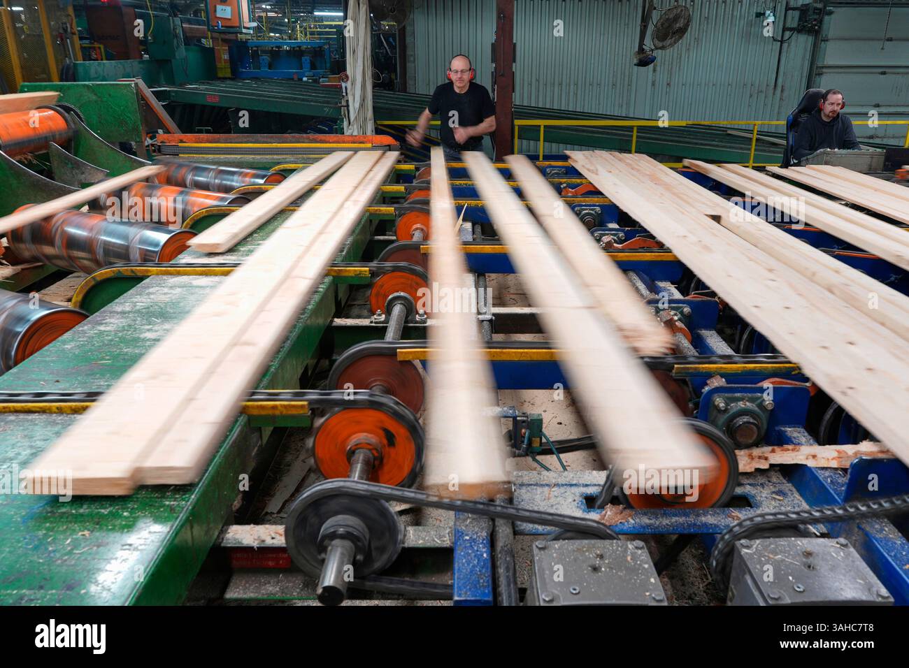 Poland Beloin, top center, guides lumber at the Marcel Lauzon sawmill ...