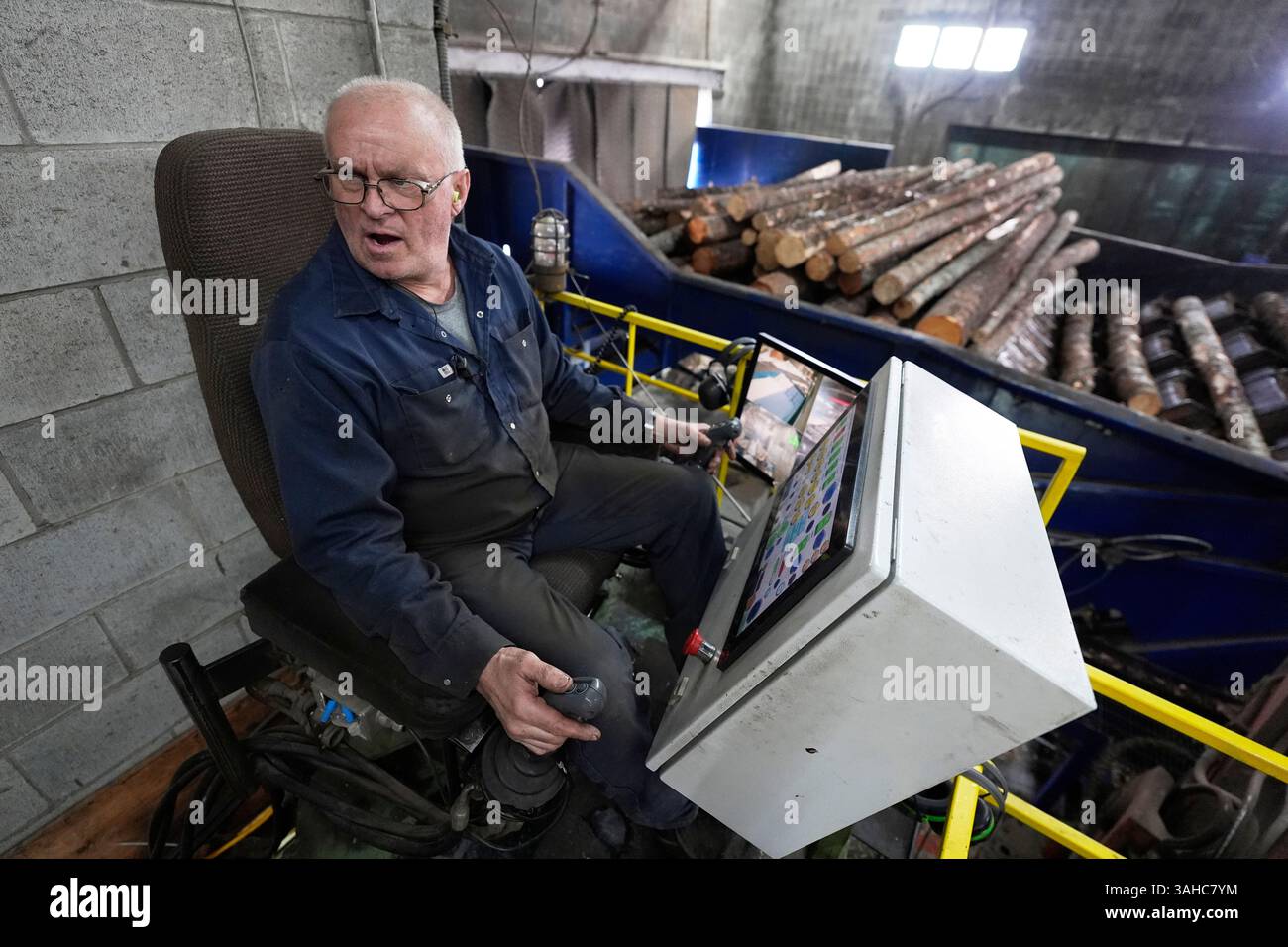 Normand Blais operates machinery that feeds logs into the milling ...