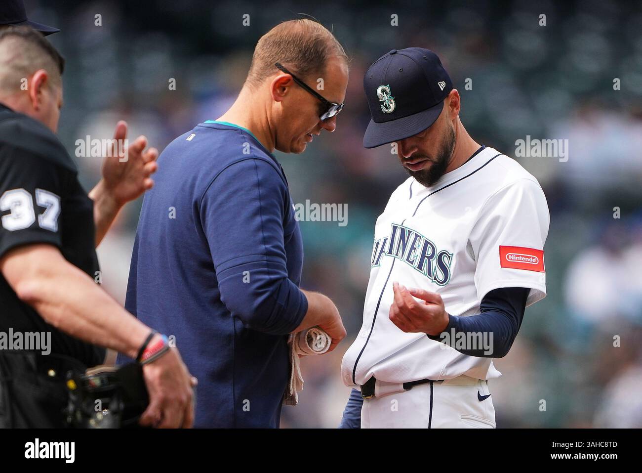 Seattle Mariners relief pitcher Casey Lawrence is checked by a trainer ...