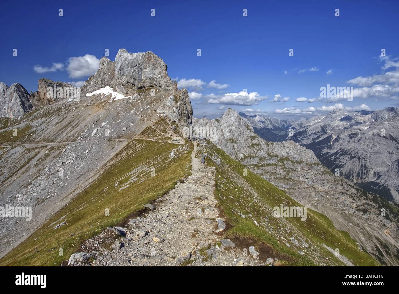 A narrow hiking trail leads over a mountain ridge, Karwendel ...