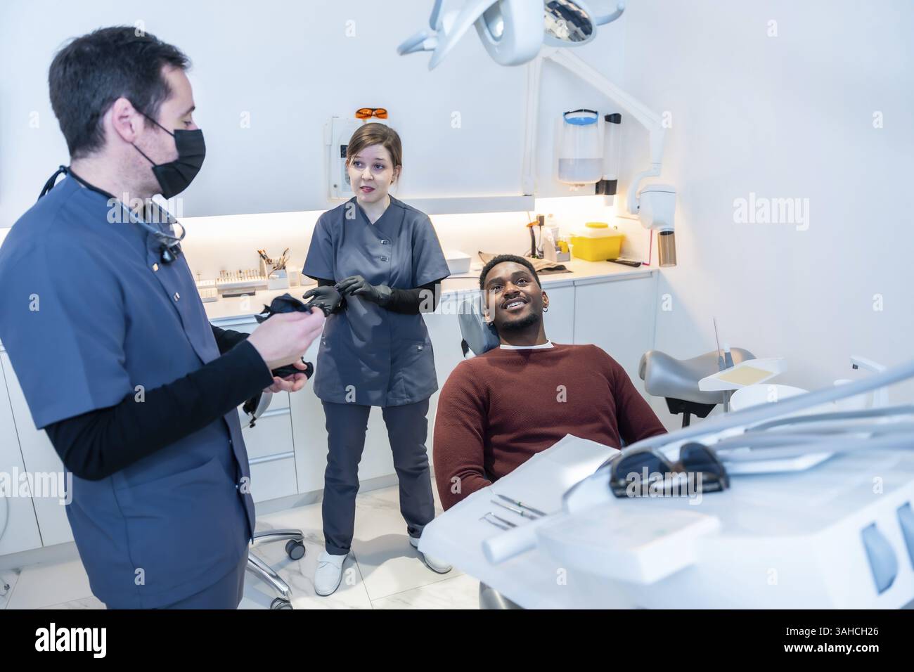 Dentist and assistant preparing for a dental check up, ensuring patient ...