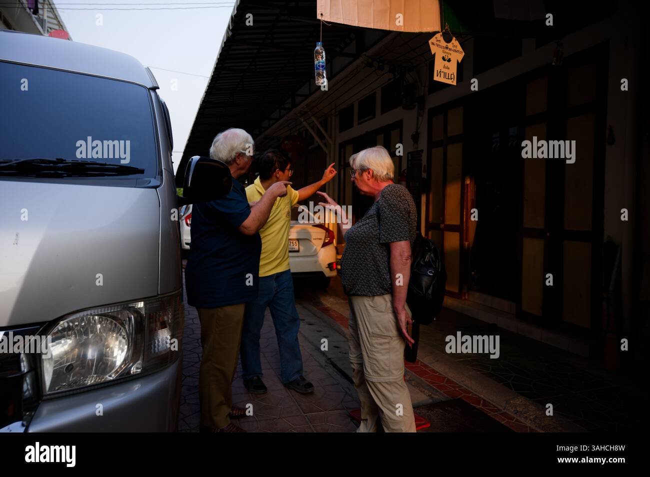 Elder tourists engage in animated conversation with their van driver ...