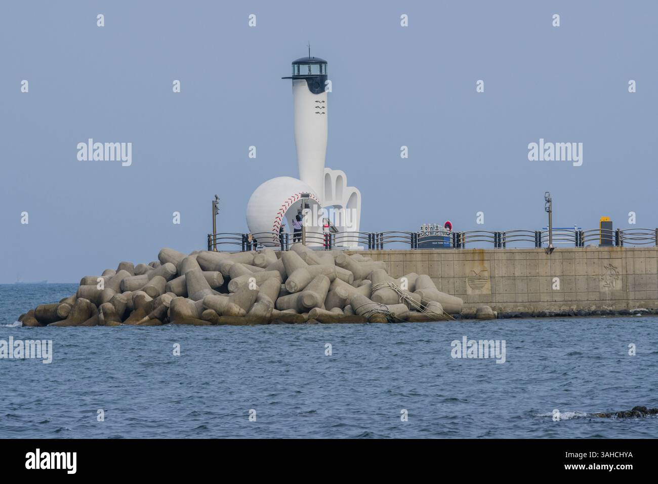 Modern white lighthouse with a unique design standing on a concrete ...