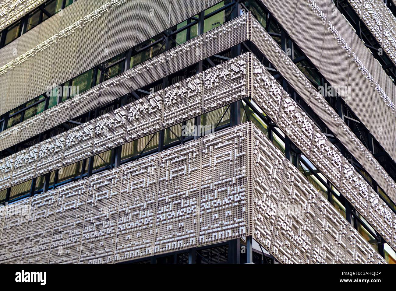 Modern building facade features intricate, perforated metal panels with ...