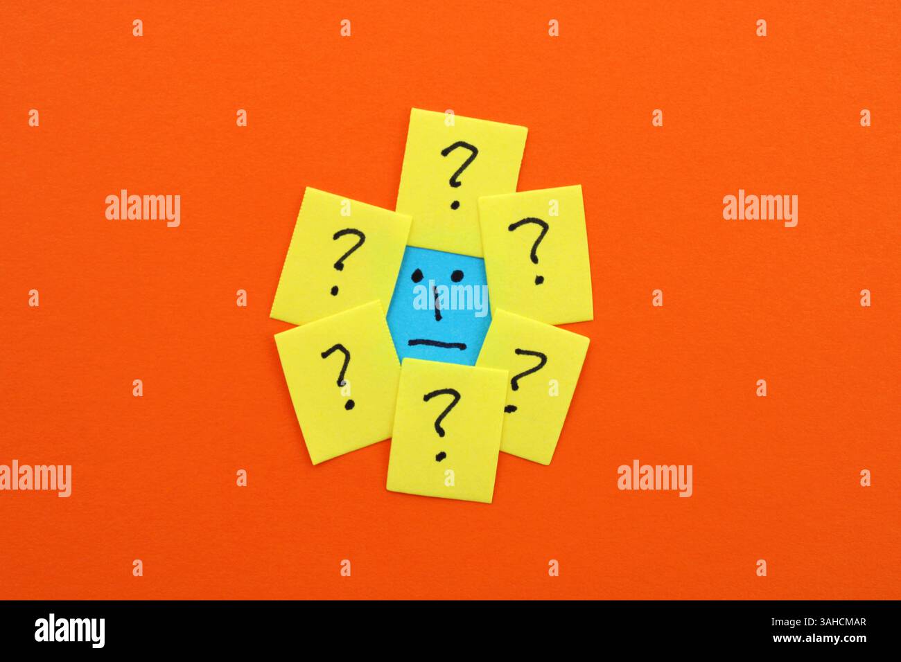 Papers with question marks surrounding a worried face Stock Photo - Alamy