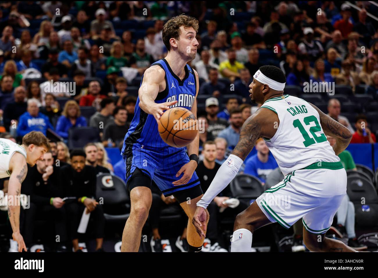 Orlando Magic forward Franz Wagner, left, passes the ball around Boston ...