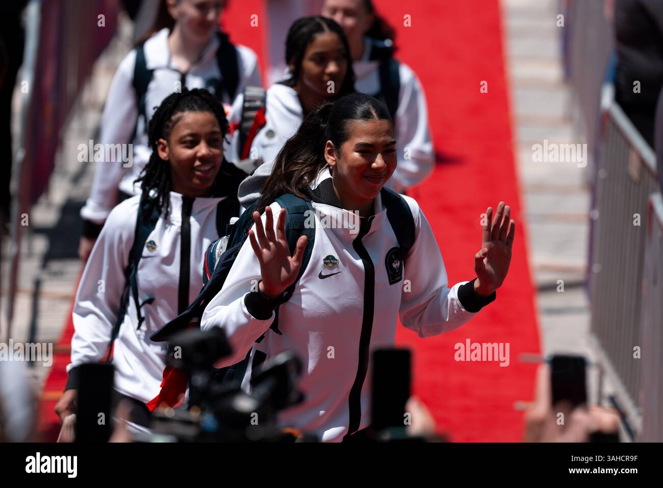 UConn Huskies center Jana El Alfy (8) and guard KK Arnold (2) walk the red carpet into the arena ...