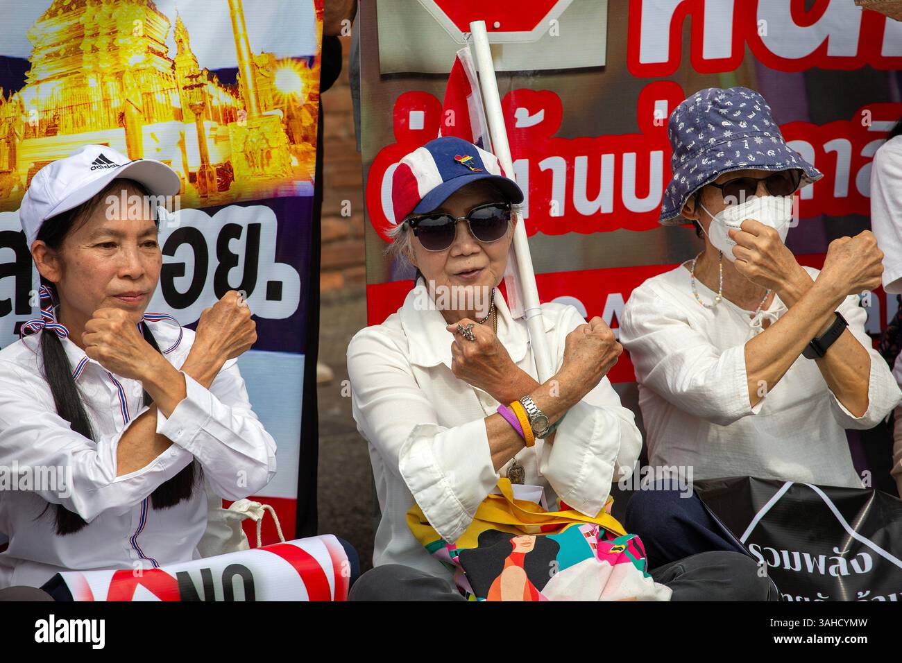 Thai protesters make a cross symbol during a demonstration to protest ...