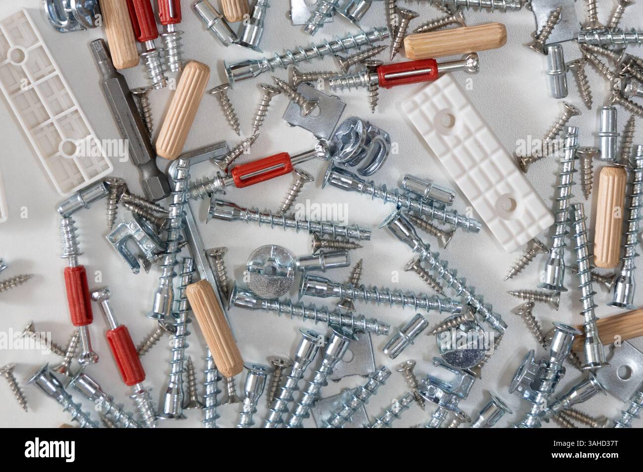 Assorted screws, bolts, and furniture fittings shown in a close-up on a ...