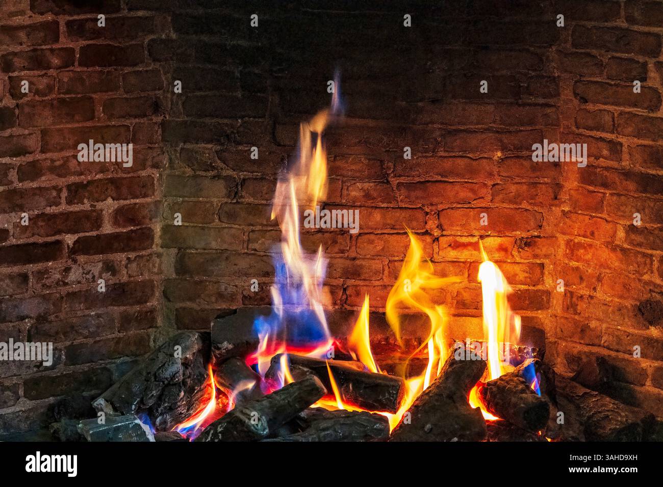 Brick fireplace with cozy flames Stock Photo - Alamy