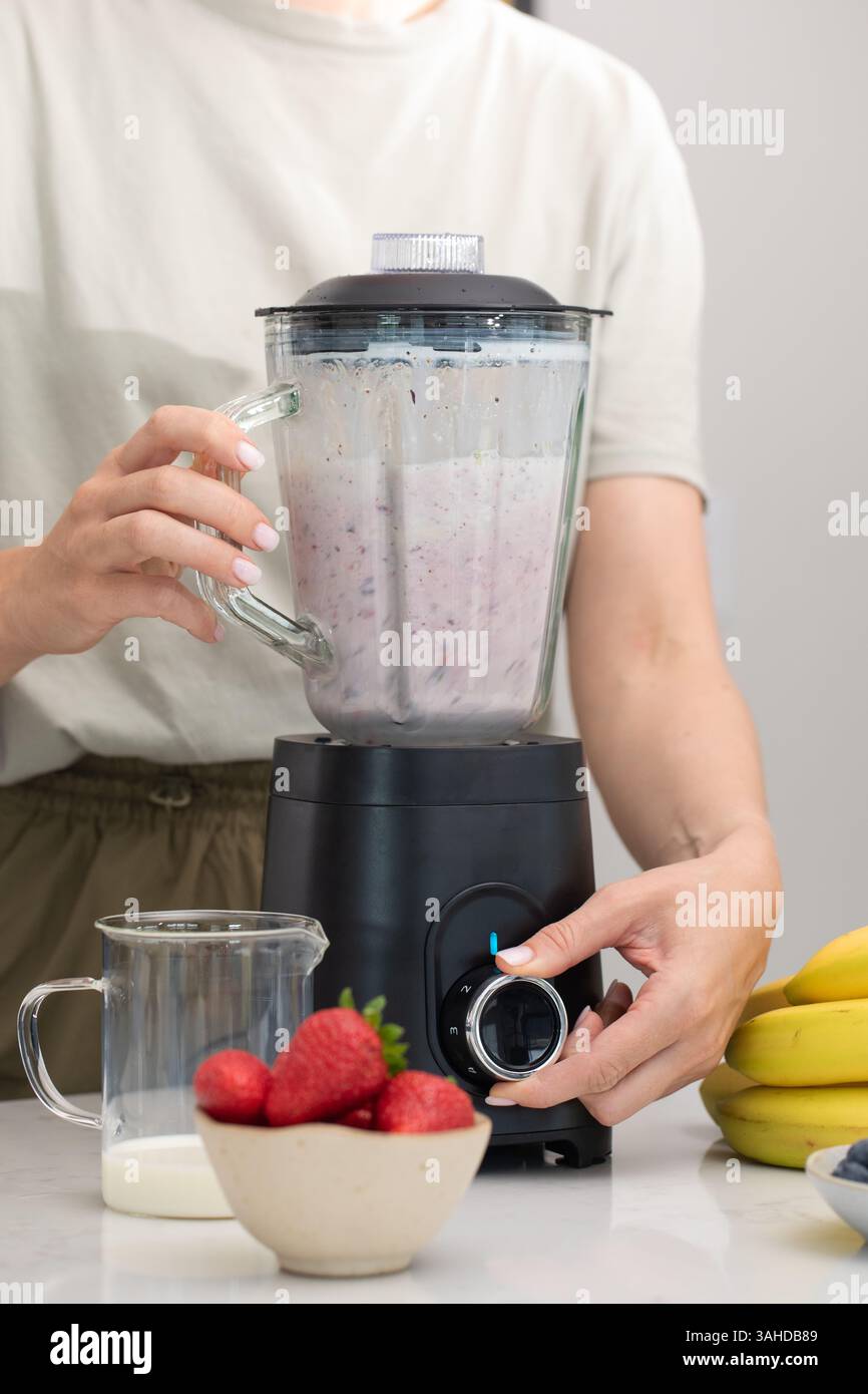 Making a fresh berry smoothie in modern kitchen setting for healthy ...