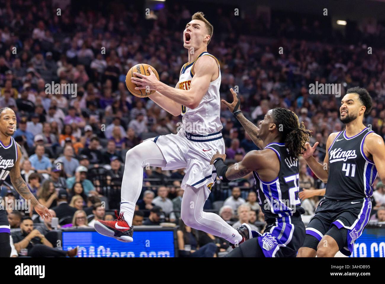 Denver Nuggets guard Christian Braun, center, makes a layup past ...