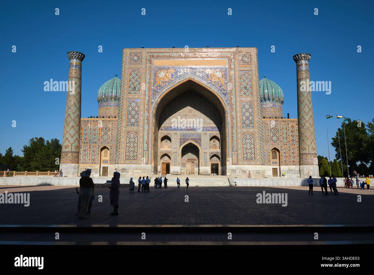 Afternoon sun shines on the front facade of the Sherdor Madrassah. At ...