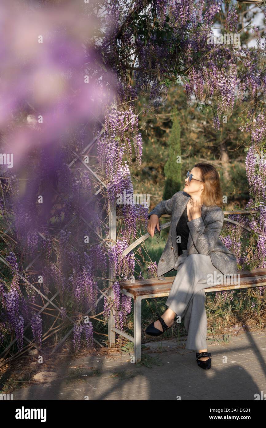 Woman Wisteria Flowers Bench - Woman sitting on a bench under a ...