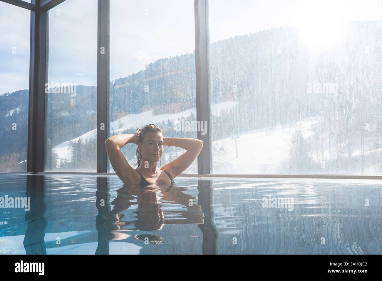 Woman Relaxing in Indoor Infinity Pool Overlooking Italian Alps Stock ...