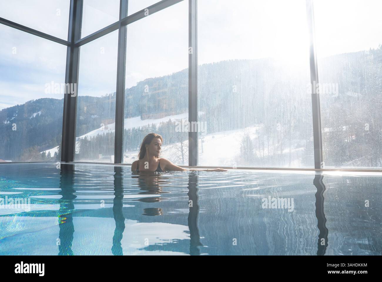 Woman Relaxing in Indoor Infinity Pool Overlooking Italian Alps Stock ...