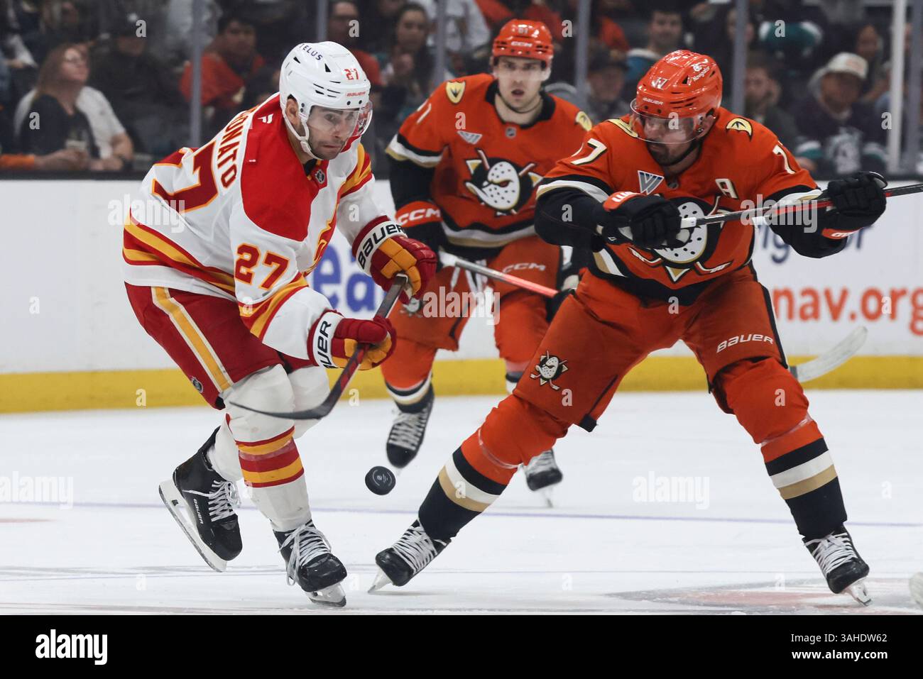 Calgary Flames winger Matt Coronato, left, controls the puck away from ...
