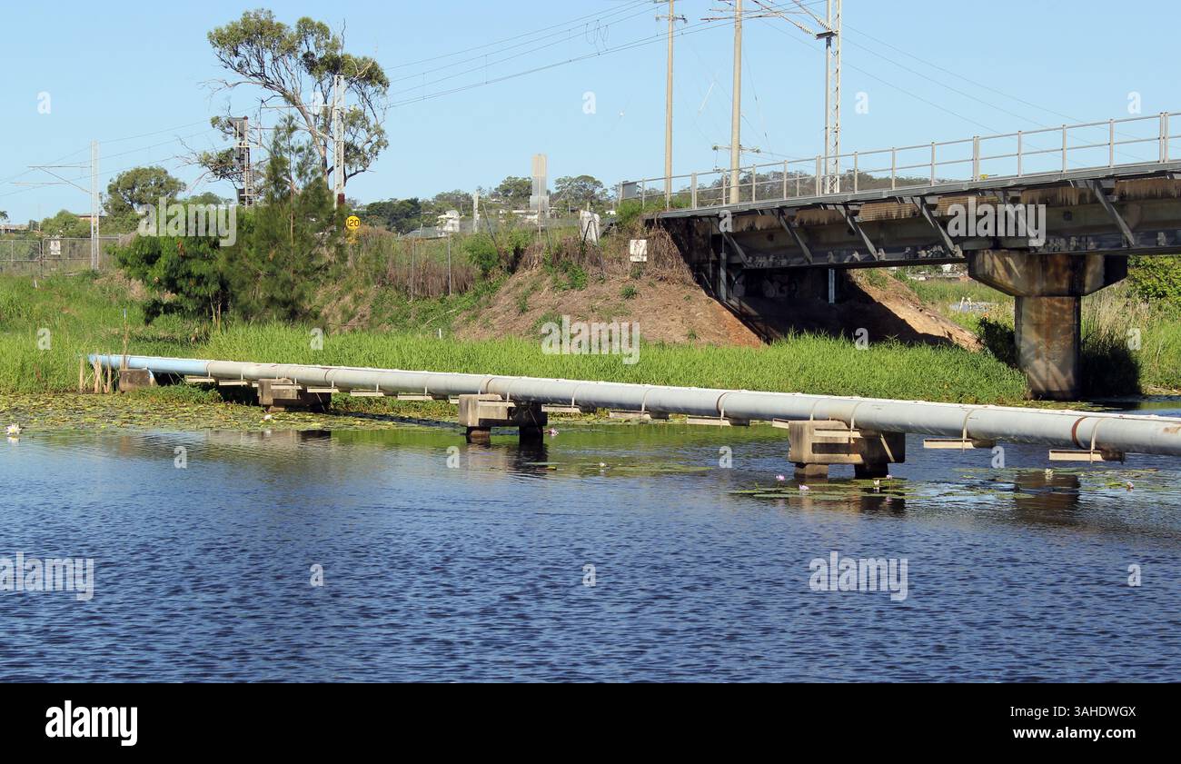 Pipeline and bridge over a lake of water Stock Photo - Alamy