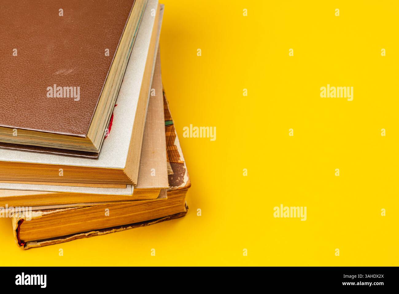 A collection of various books stacked together on a bright yellow ...