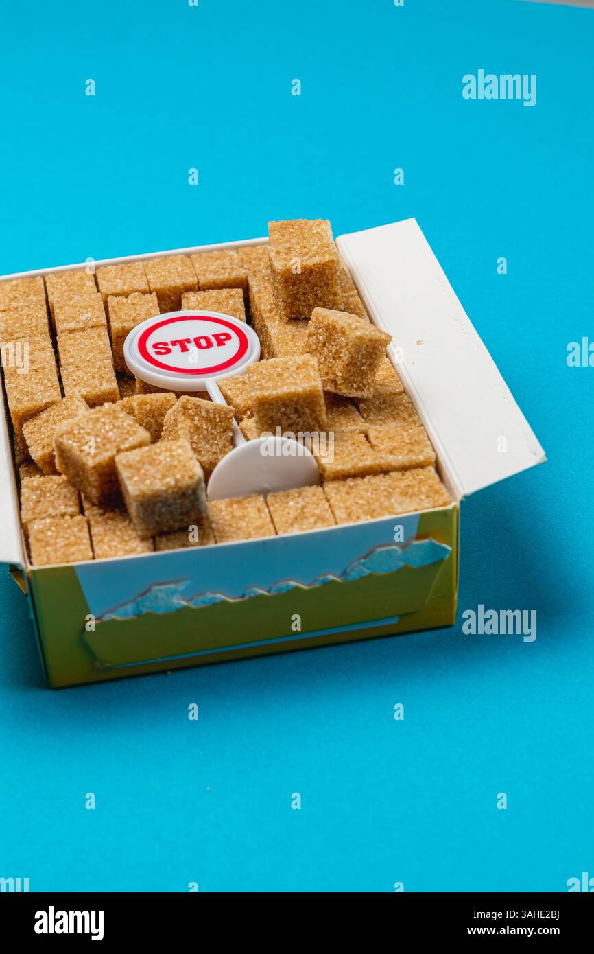 A box filled with brown sugar cubes features a red stop sign. Bright ...