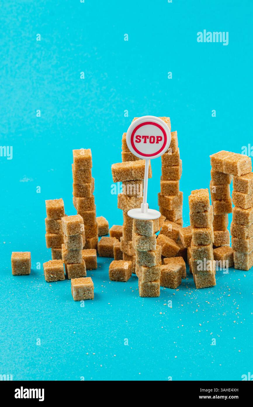 Sugar cubes are arranged in various heights on a vibrant blue ...