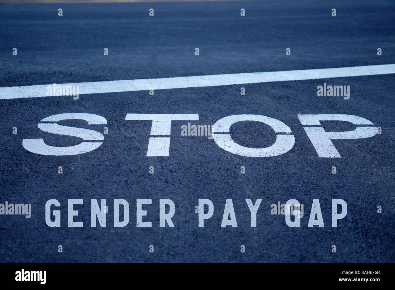 stop gender pay gap concept. words written on the asphalt at a highway ...