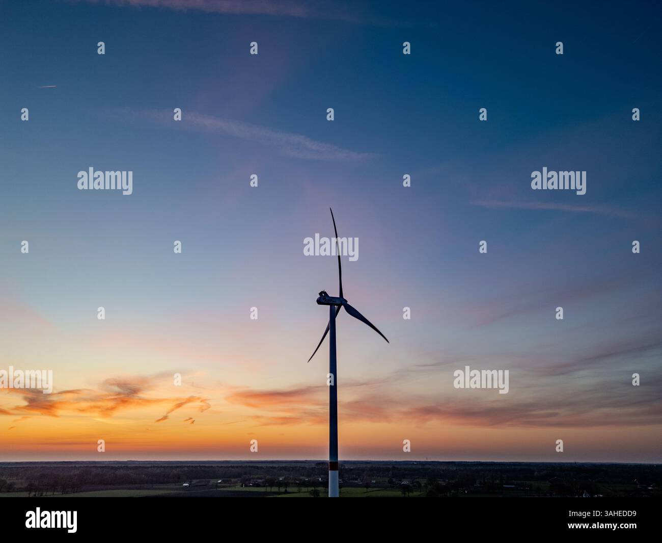 A stunning and picturesque sunset scene showcasing a wind turbine ...