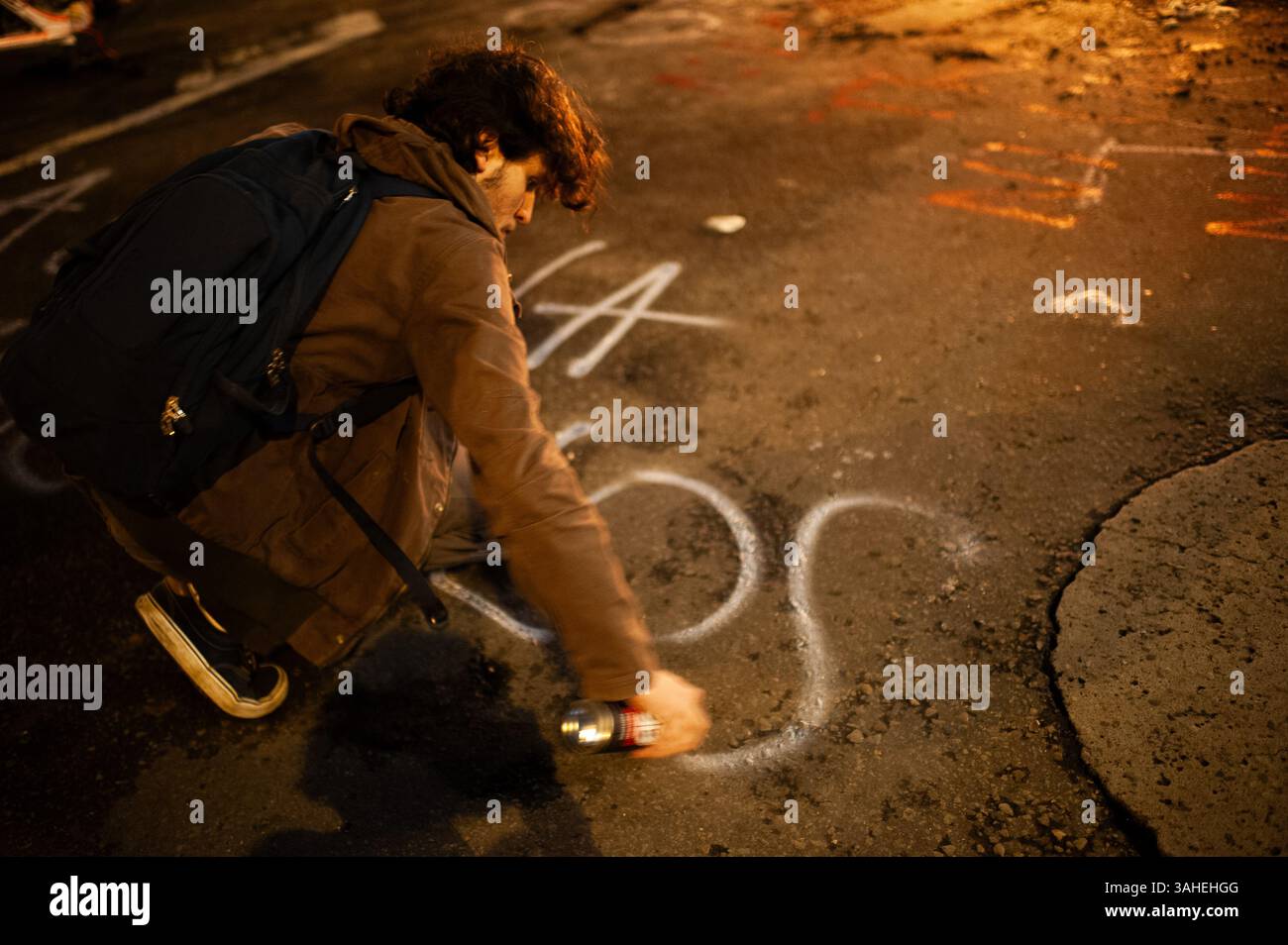 Demonstrators block a road with a bonfire and graffiti during a protest ...