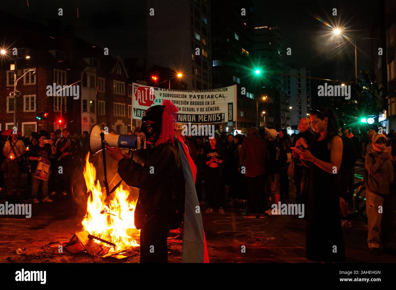 Demonstrators block a road with a bonfire and graffiti during a protest ...