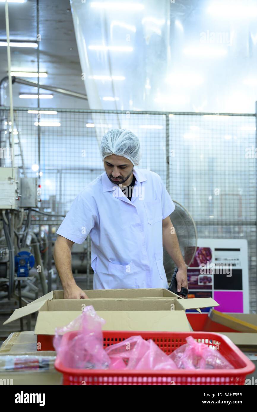 Factory worker sorting products in packaging area of a modern food ...