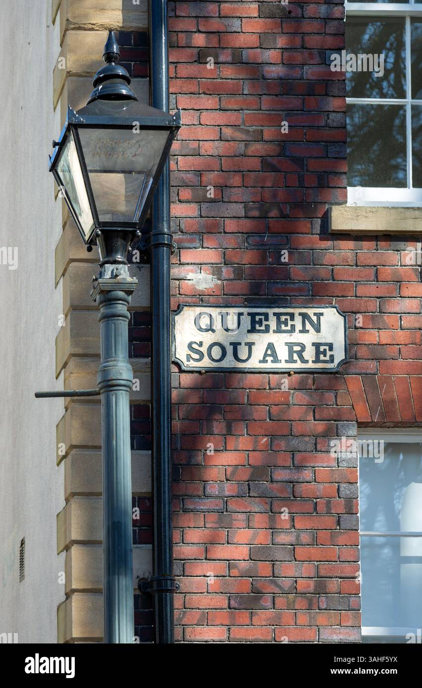 Historic lamppost and street sign on red brick Georgian building, Queen ...