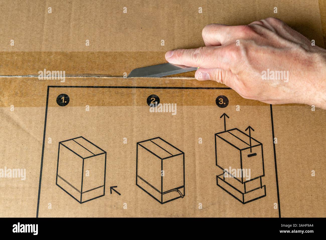 Unpacking a large gray cardboard box, knife on a cardboard box, opening ...