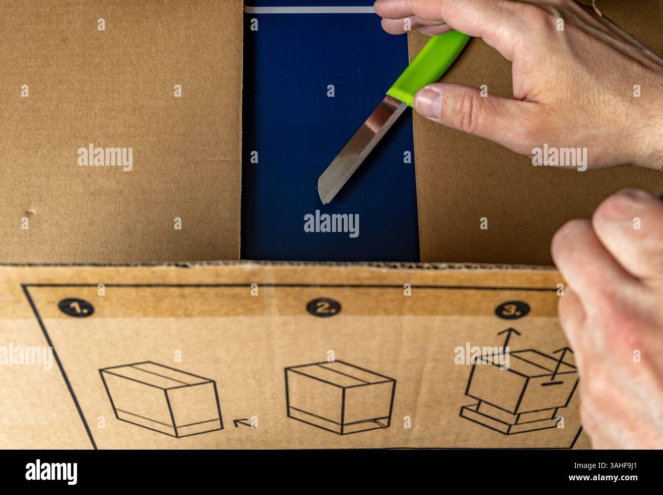 Unpacking a large gray cardboard box, knife on a cardboard box, opening ...