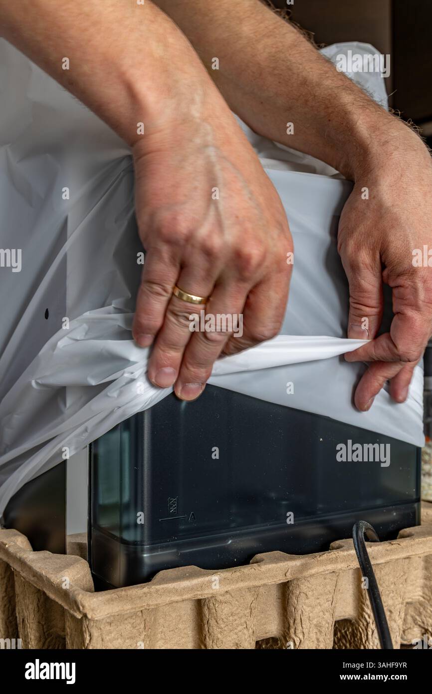 Taking a new coffee machine out of the cardboard box, unpacking a new ...