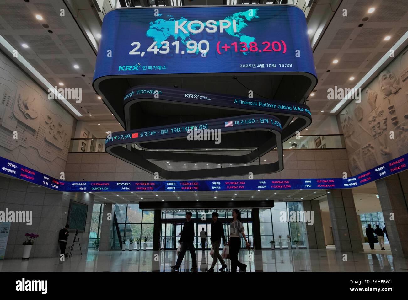 People pass by a screen showing the Korea Composite Stock Price Index ...