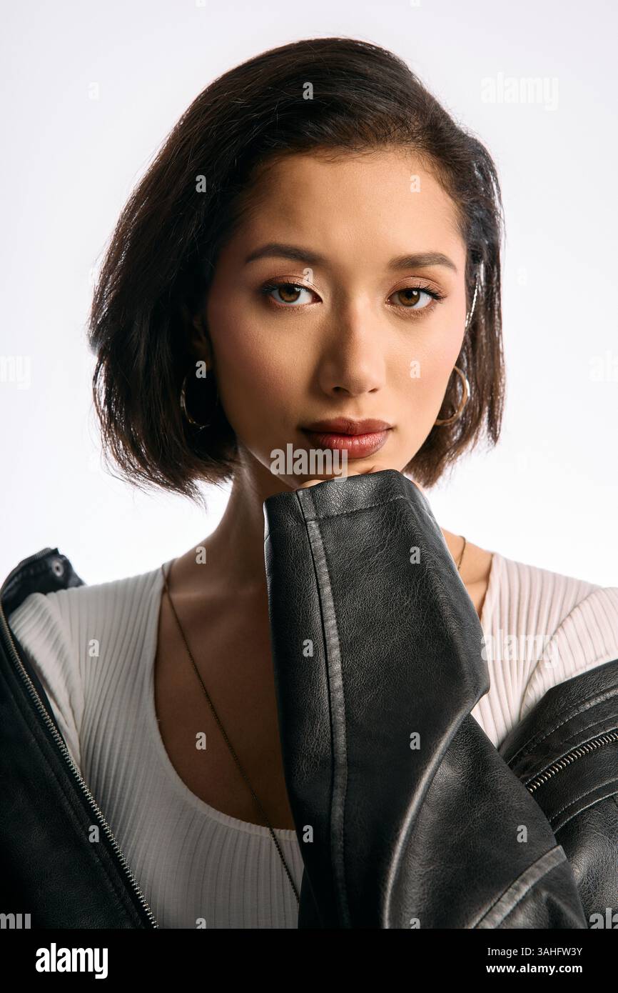 Confident woman poses with a leather jacket while showcasing her trendy ...