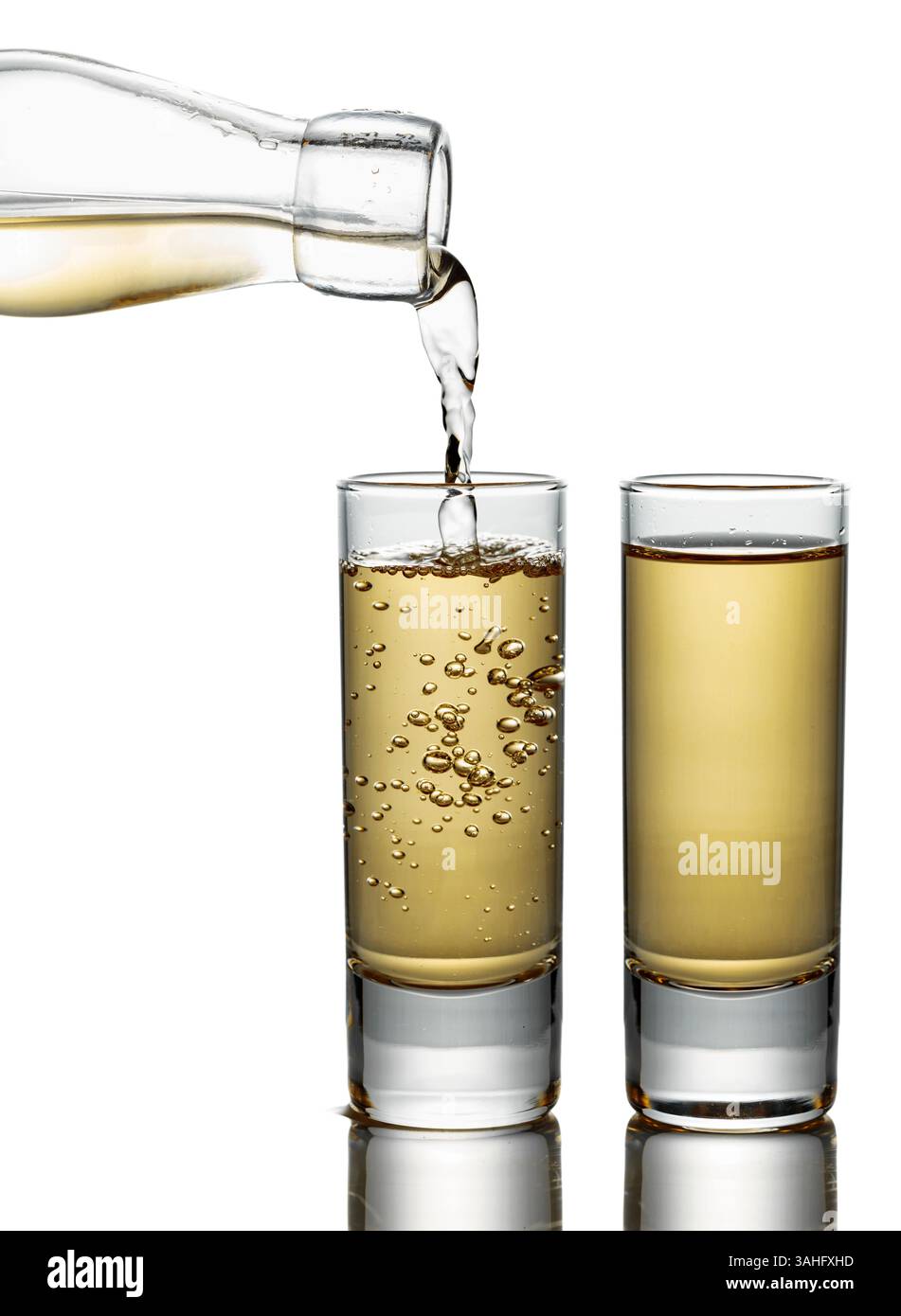 Gold liquor pouring into a glass. Isolated on a white background Stock ...