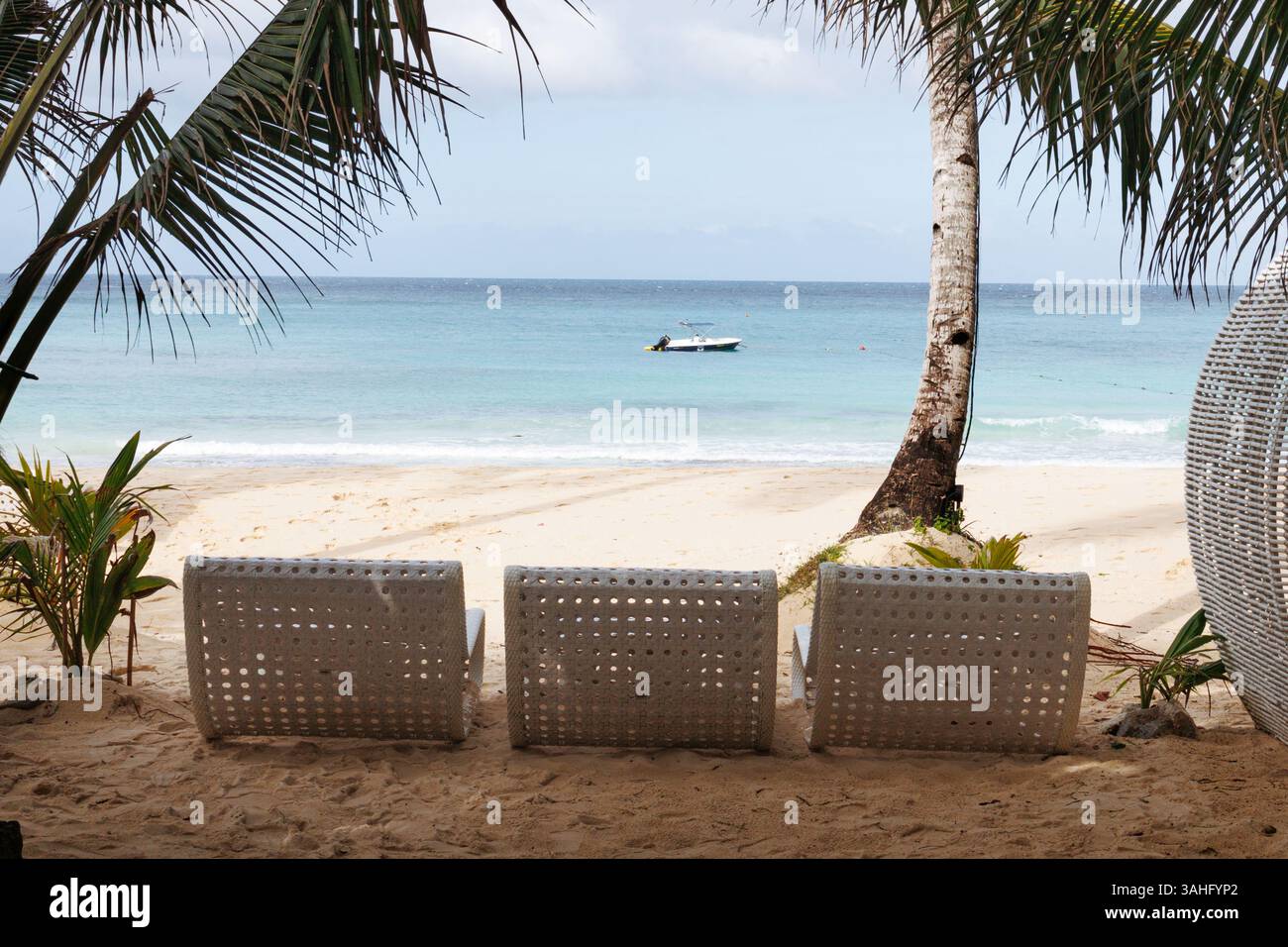 Relaxing beach setup with lounge chairs overlooking calm ocean waters ...