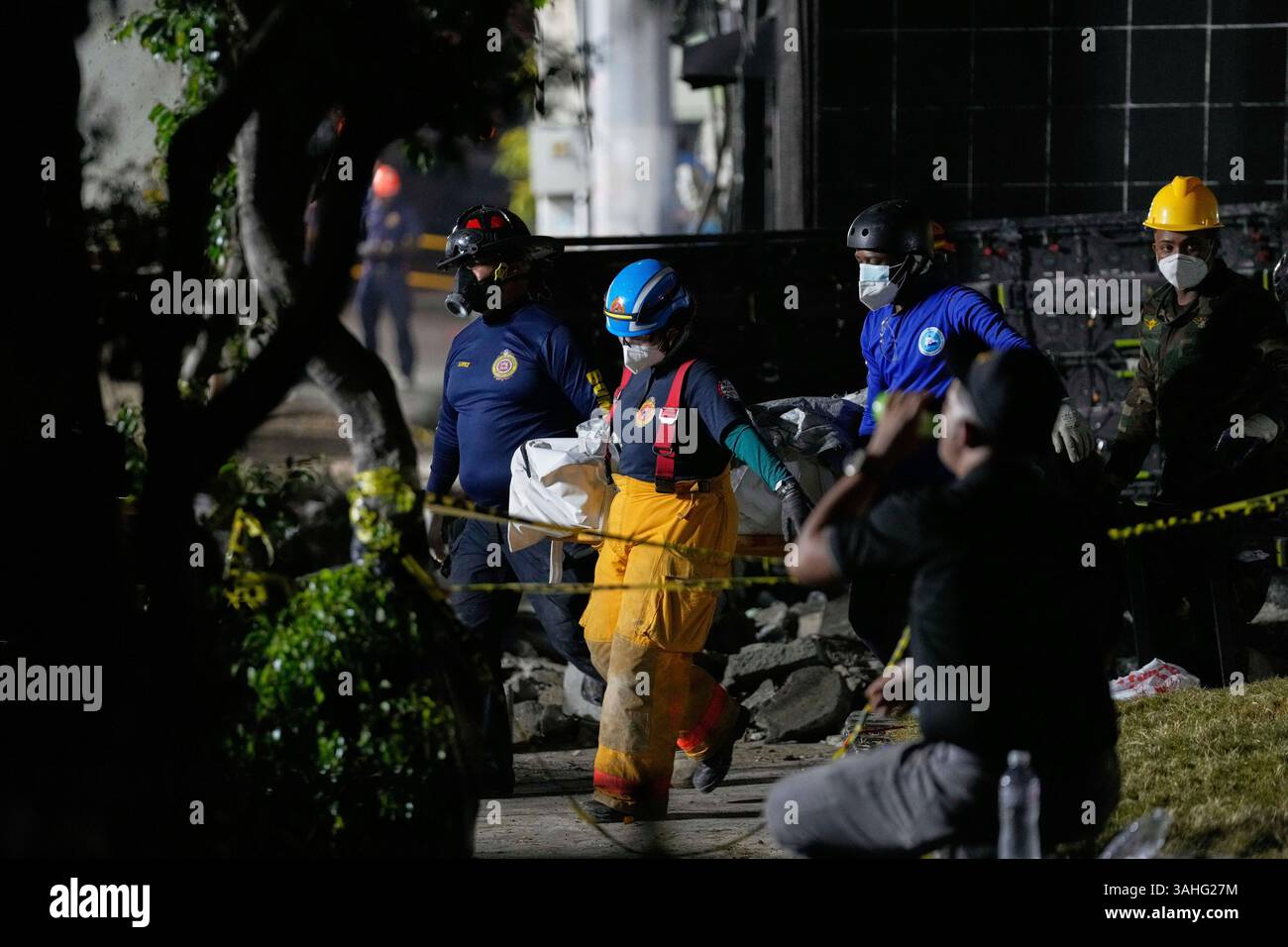 Rescue workers carry the recovered body of a victim who died when the ...