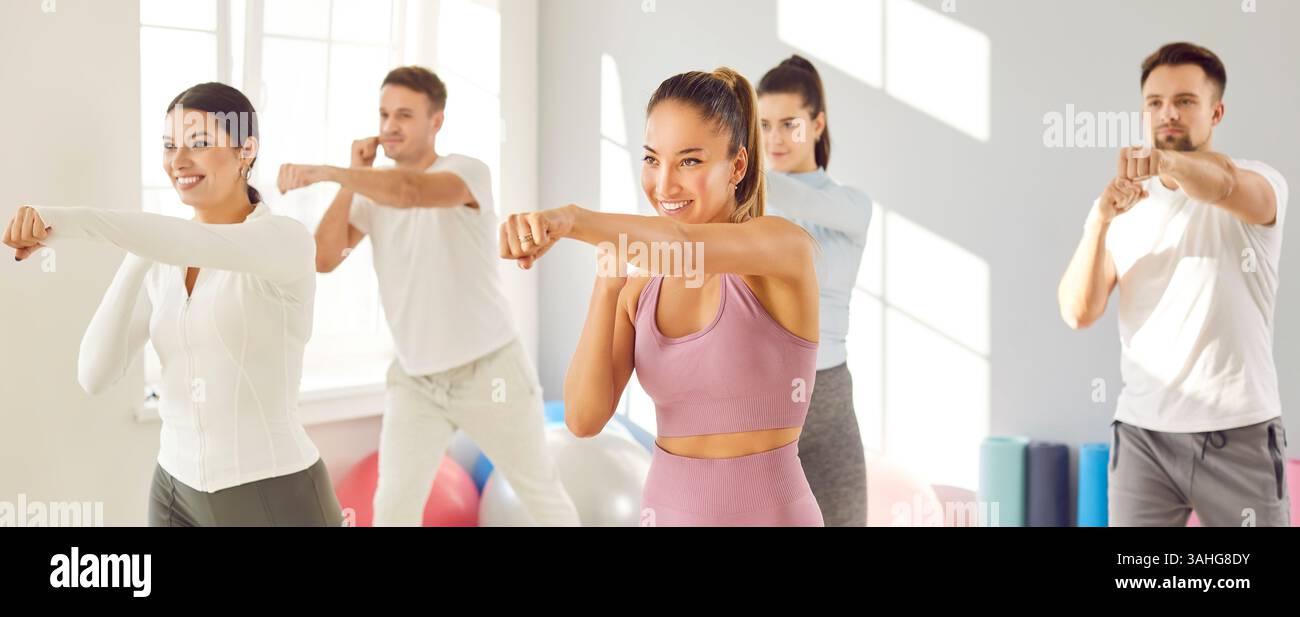 Happy smiling people doing boxing sport exercise in gym during workout ...