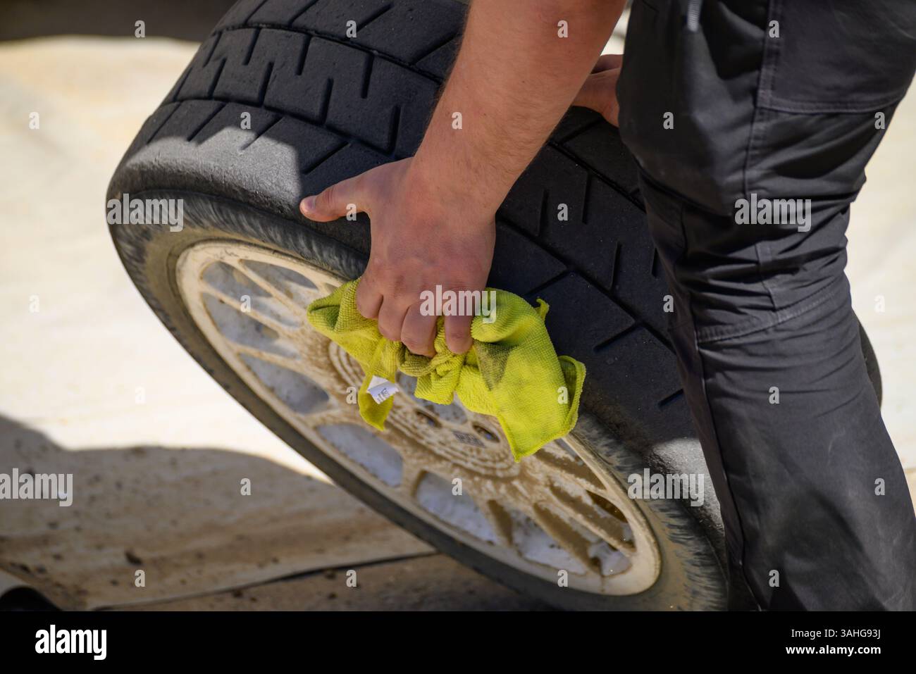 mechanic hand cleaning dirty wheel race tire closeup maintenance detail ...