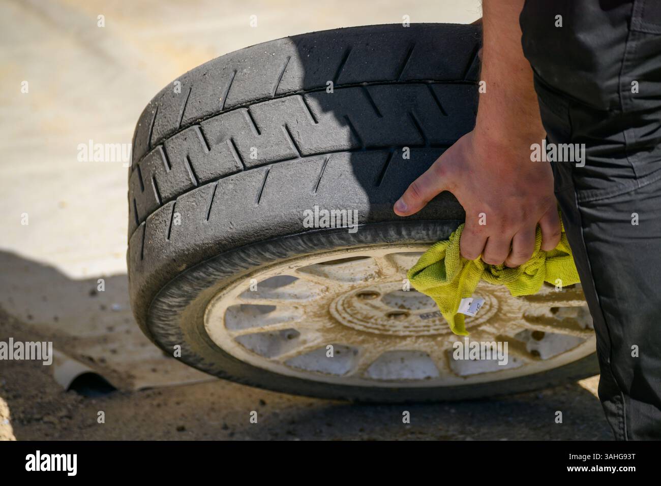 Mechanic work on race car in pit stop, race tire closeup maintenance ...
