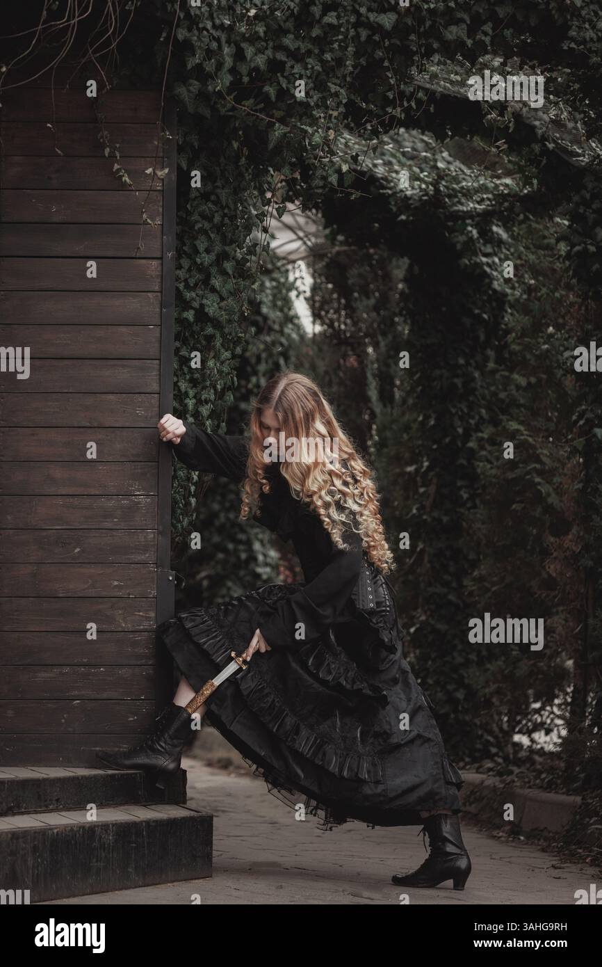Woman in dark vintage gown stepping onto wooden porch, dagger hidden in ...